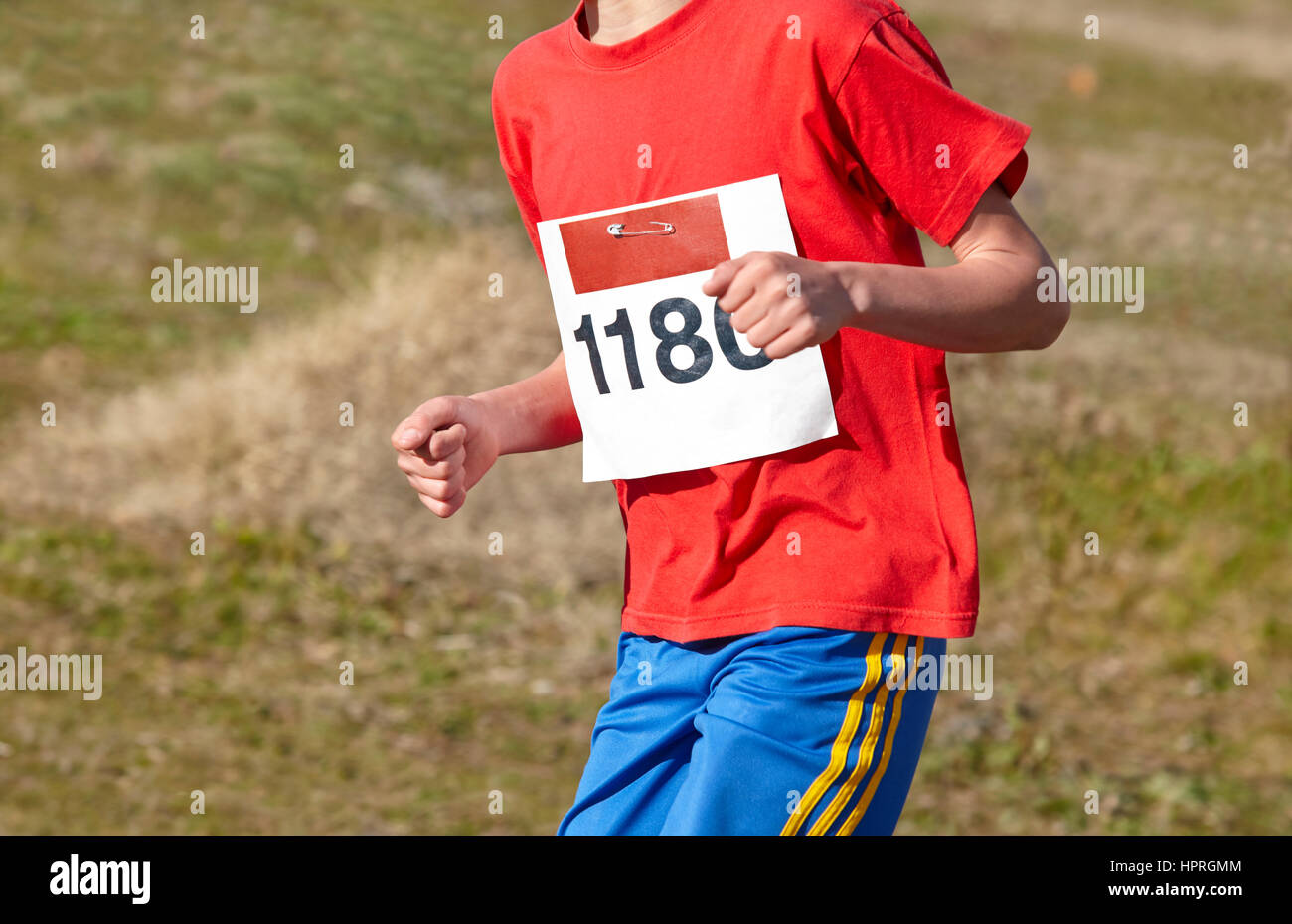 Junior athletic runner on a cross country race. Outdoor circuit ...