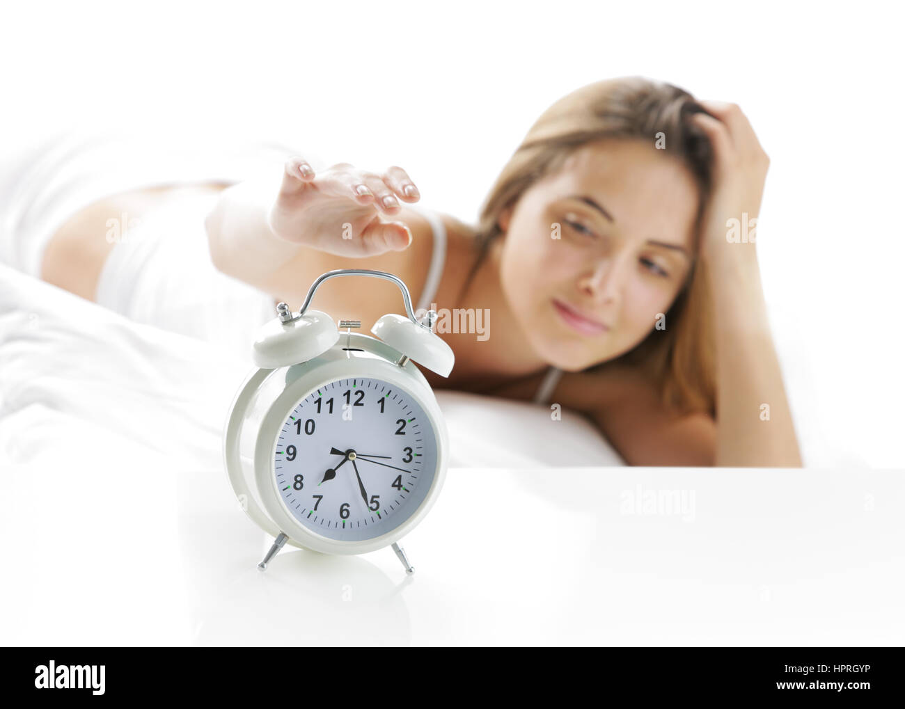 Woman turning off the alarm clock Stock Photo - Alamy