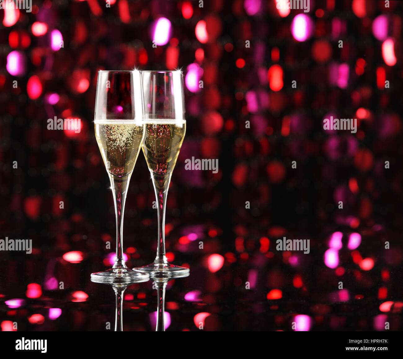 Two glasses of champagne, colored lights as background Stock Photo - Alamy