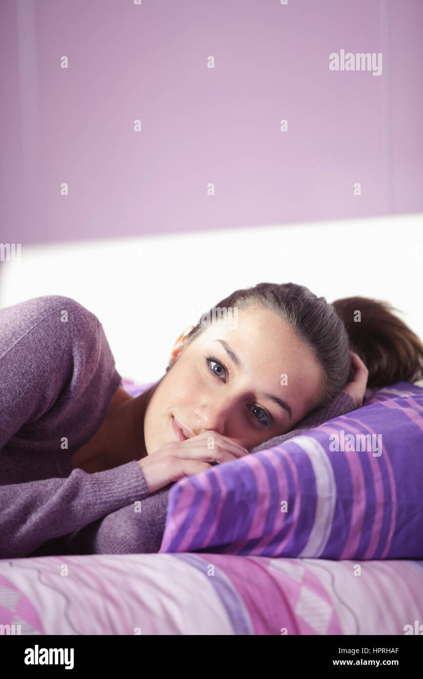 Closeup of a young woman lying on bed Stock Photo - Alamy
