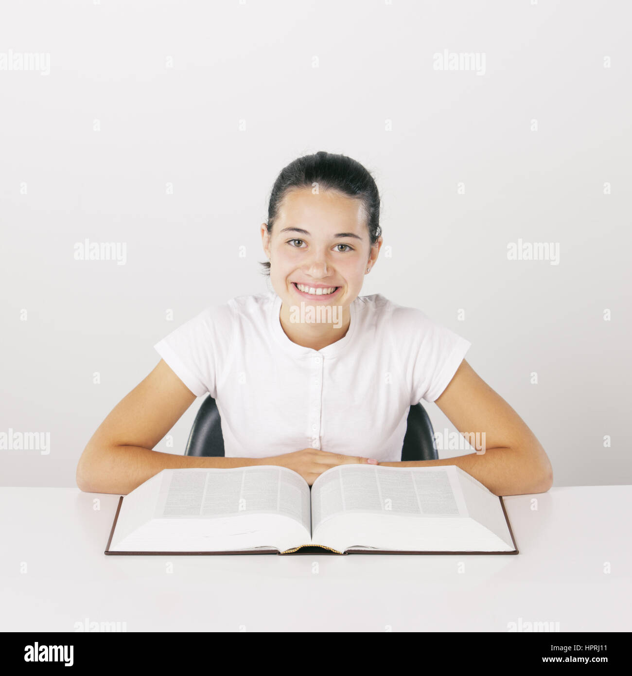 Young girl with book, smiling Stock Photo - Alamy