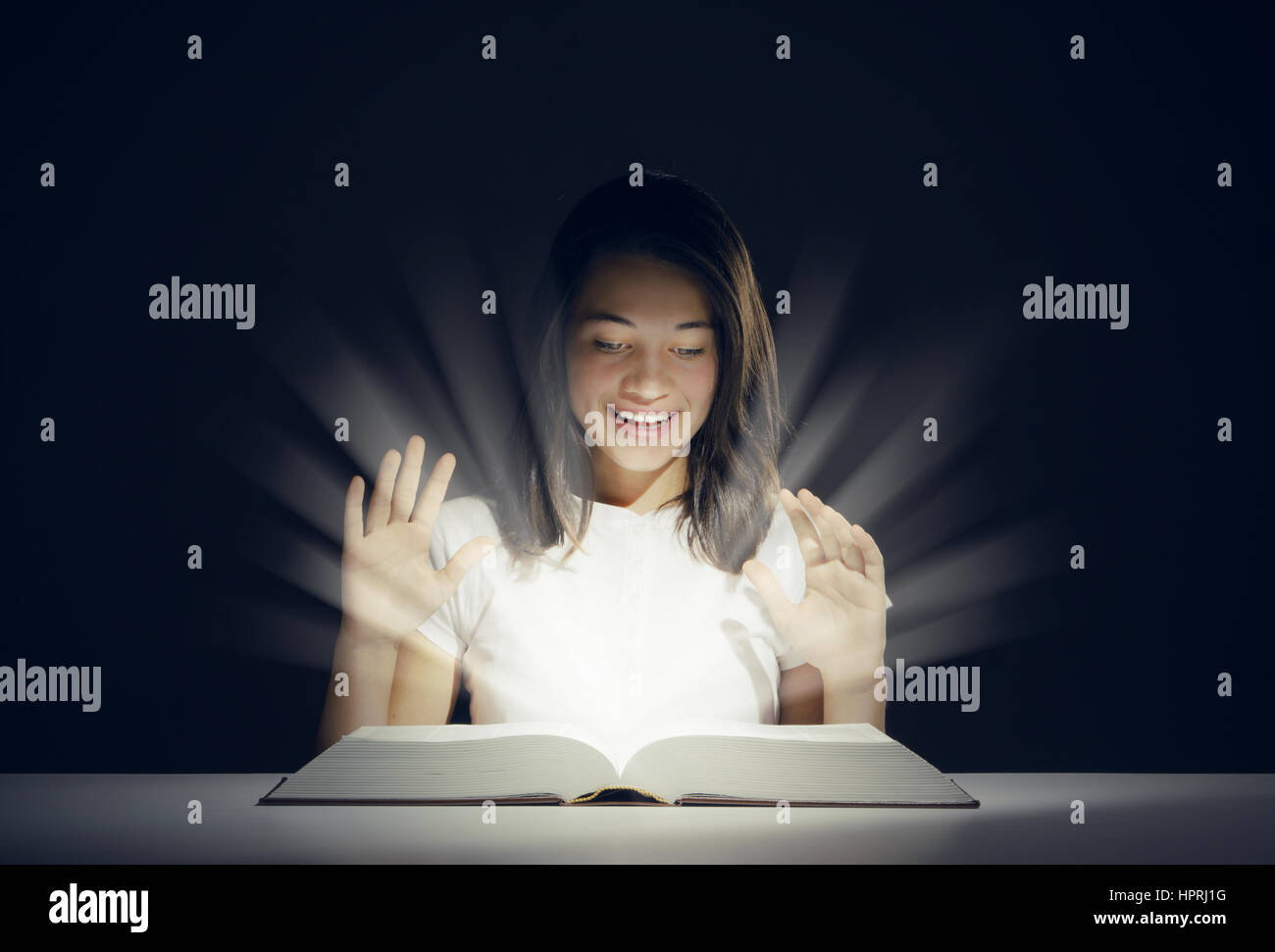 Young girl open a magic book Stock Photo - Alamy