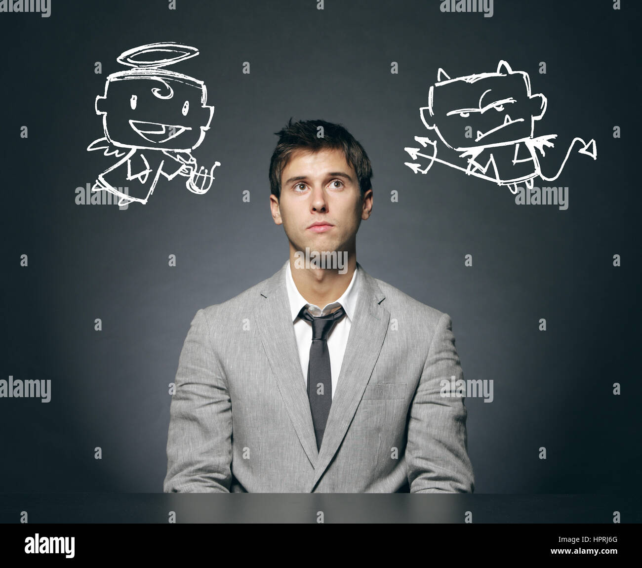 Business man confused with his good and bad conscience Stock Photo - Alamy