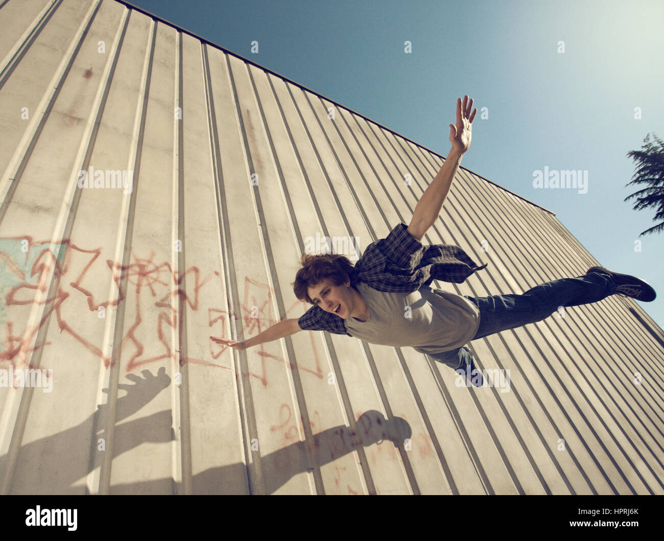 Young man flying with open arms Stock Photo - Alamy