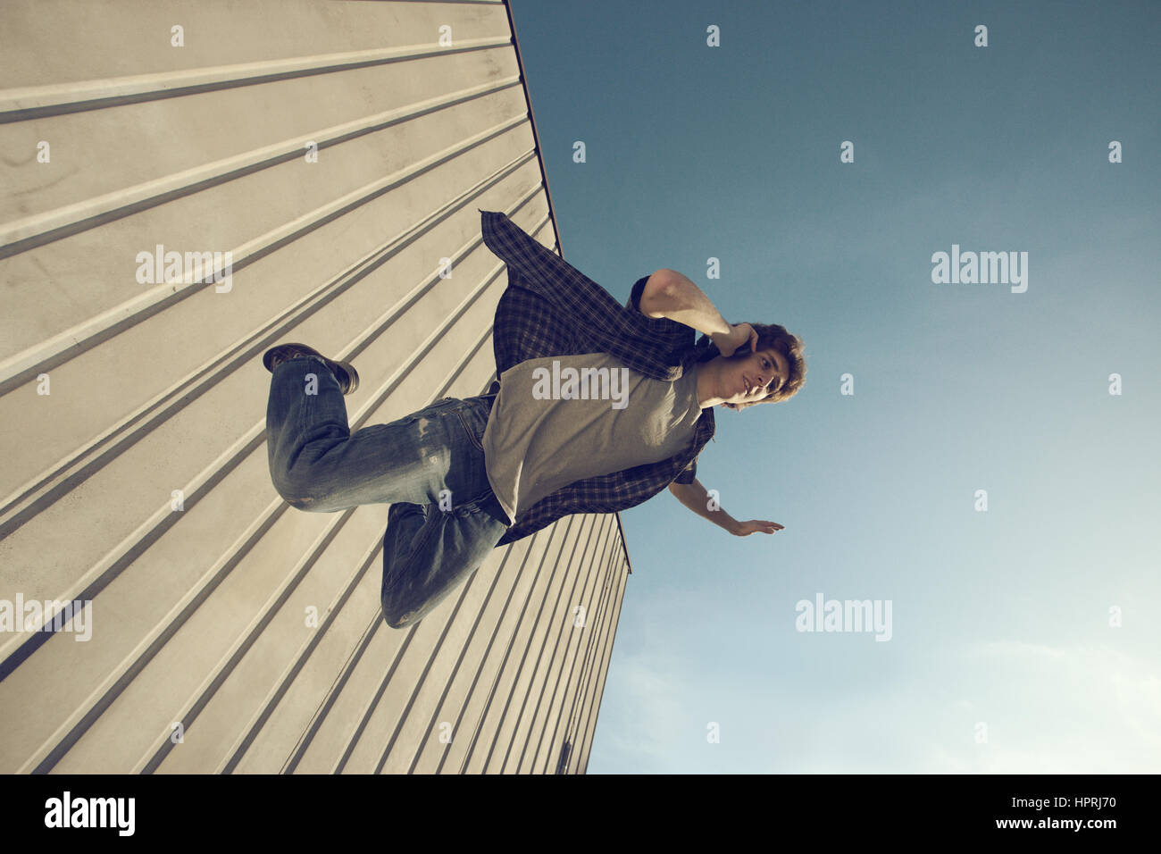 Young man is falling from a building and calling with cell phone Stock ...