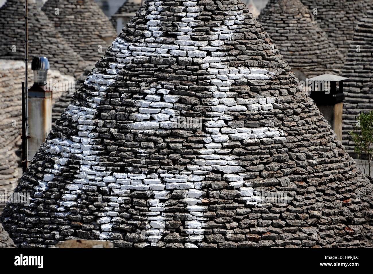 A painted sun on the roof of a so-called trullo house in the city of ...