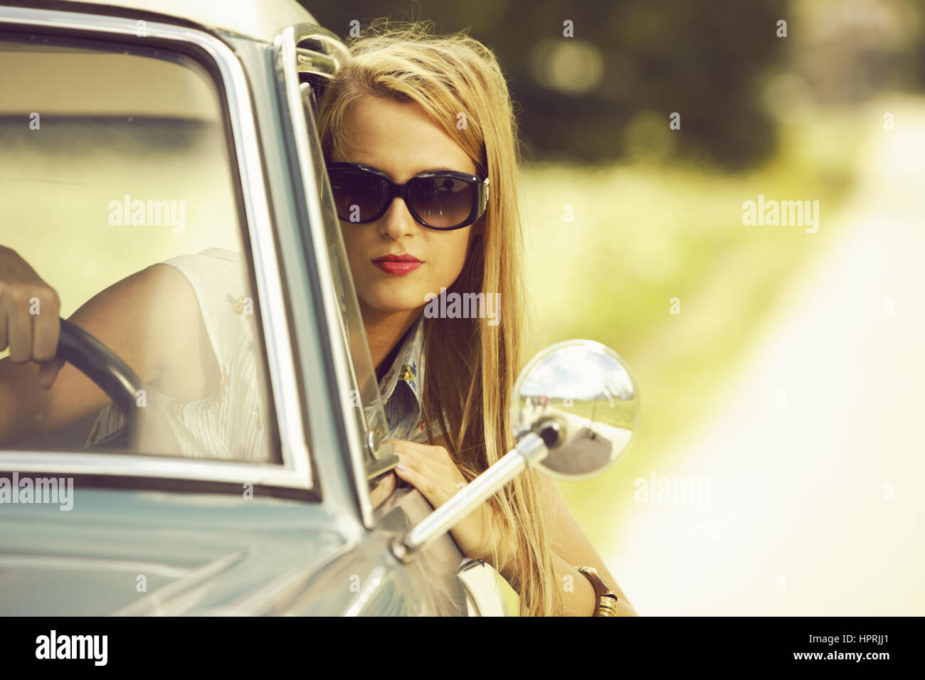 Young woman driving vintage car Stock Photo - Alamy