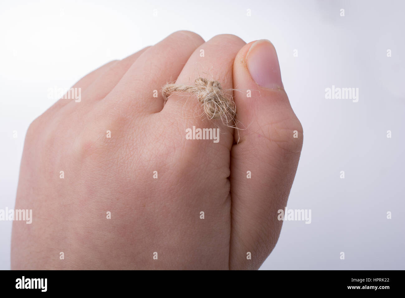 Thread knot in hand on a light color background Stock Photo - Alamy