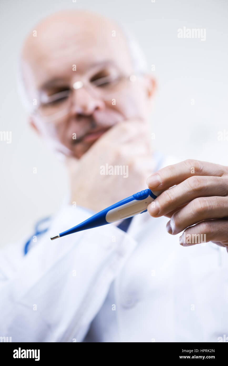 Senior male doctor measuring temperature with a thermometer Stock Photo ...