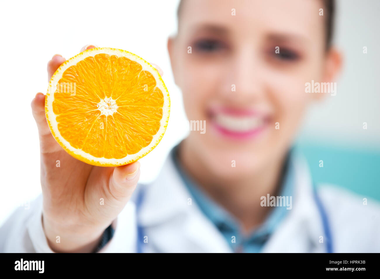 Happy female Nurse or Doctor holding an orange Stock Photo - Alamy