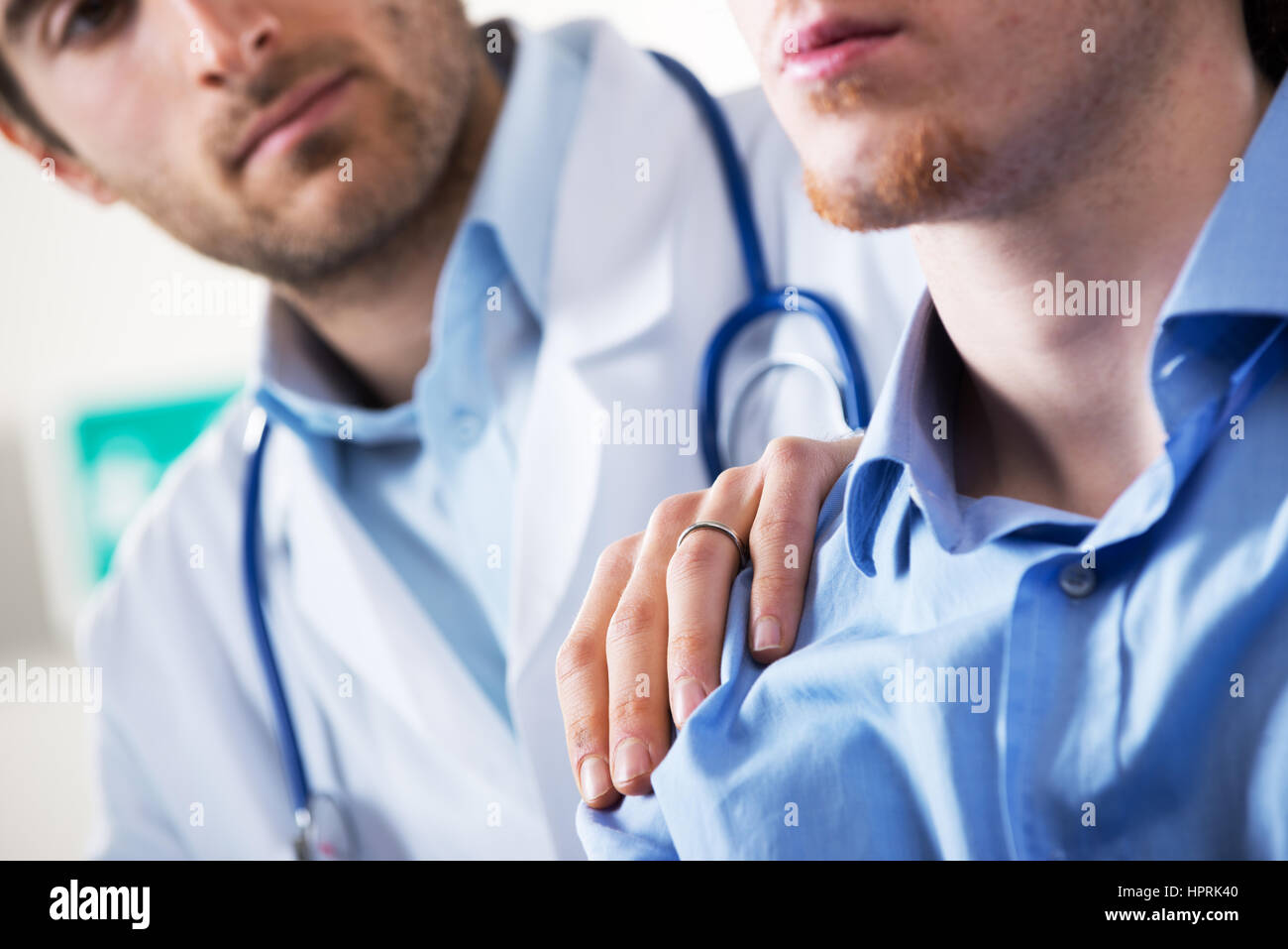 Doctor comforting a young patient after telling him bad news Stock ...