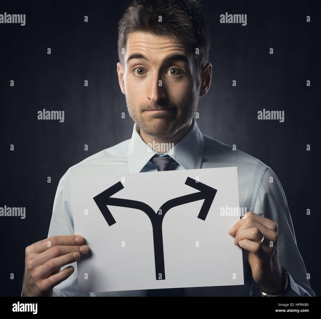 Man holding a sign with directions and pensive expression Stock Photo ...