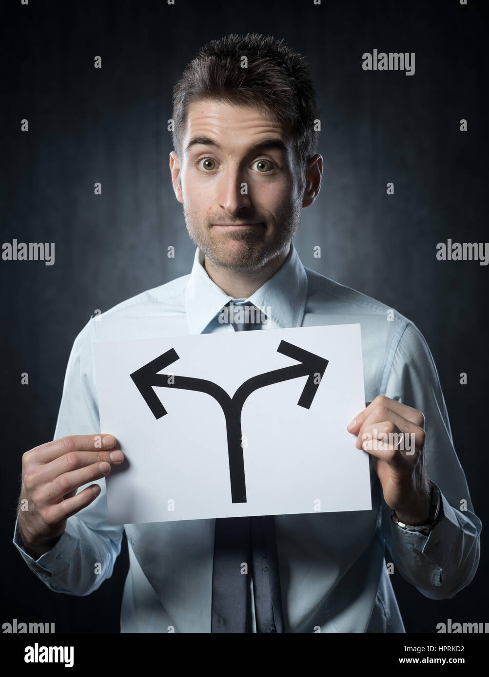 Man holding a sign with directions and pensive expression Stock Photo ...