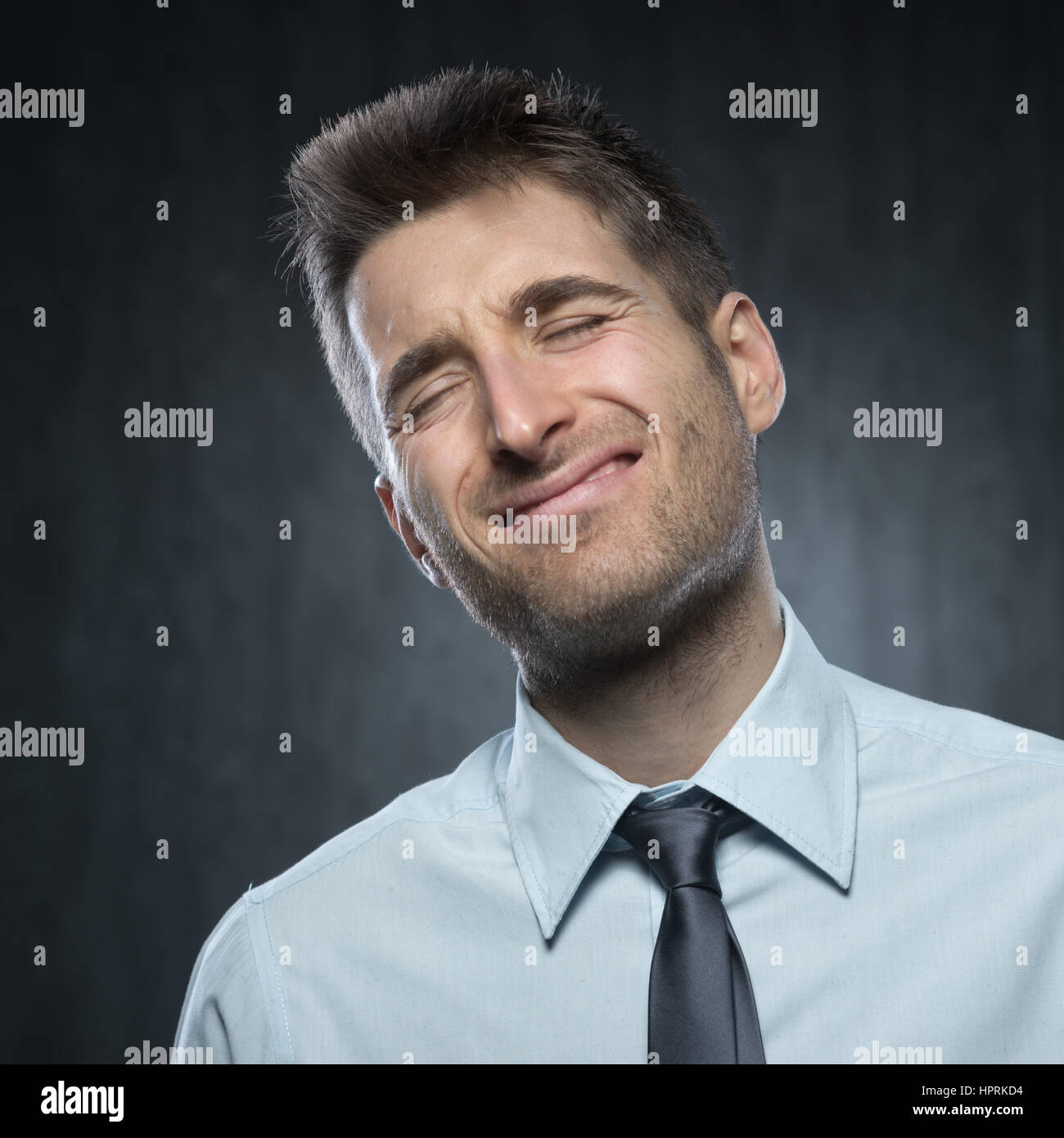 Young man with painful expression on dark background Stock Photo - Alamy