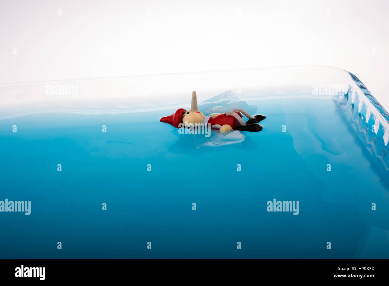 Wodden puppet Pinocchio on in blue water Stock Photo - Alamy