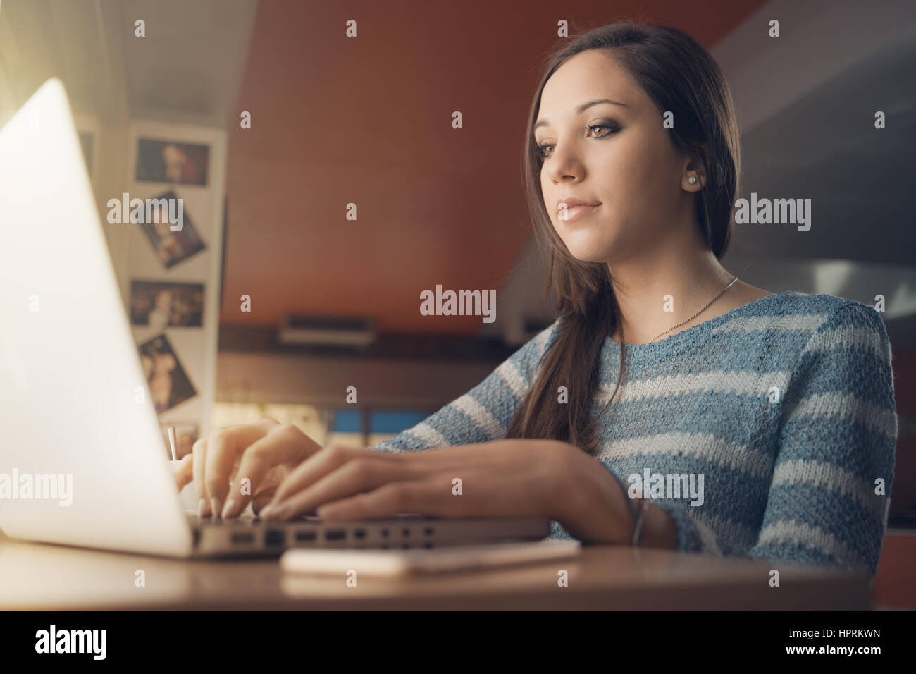 Busy young woman using a laptop and staring at computer screen Stock ...