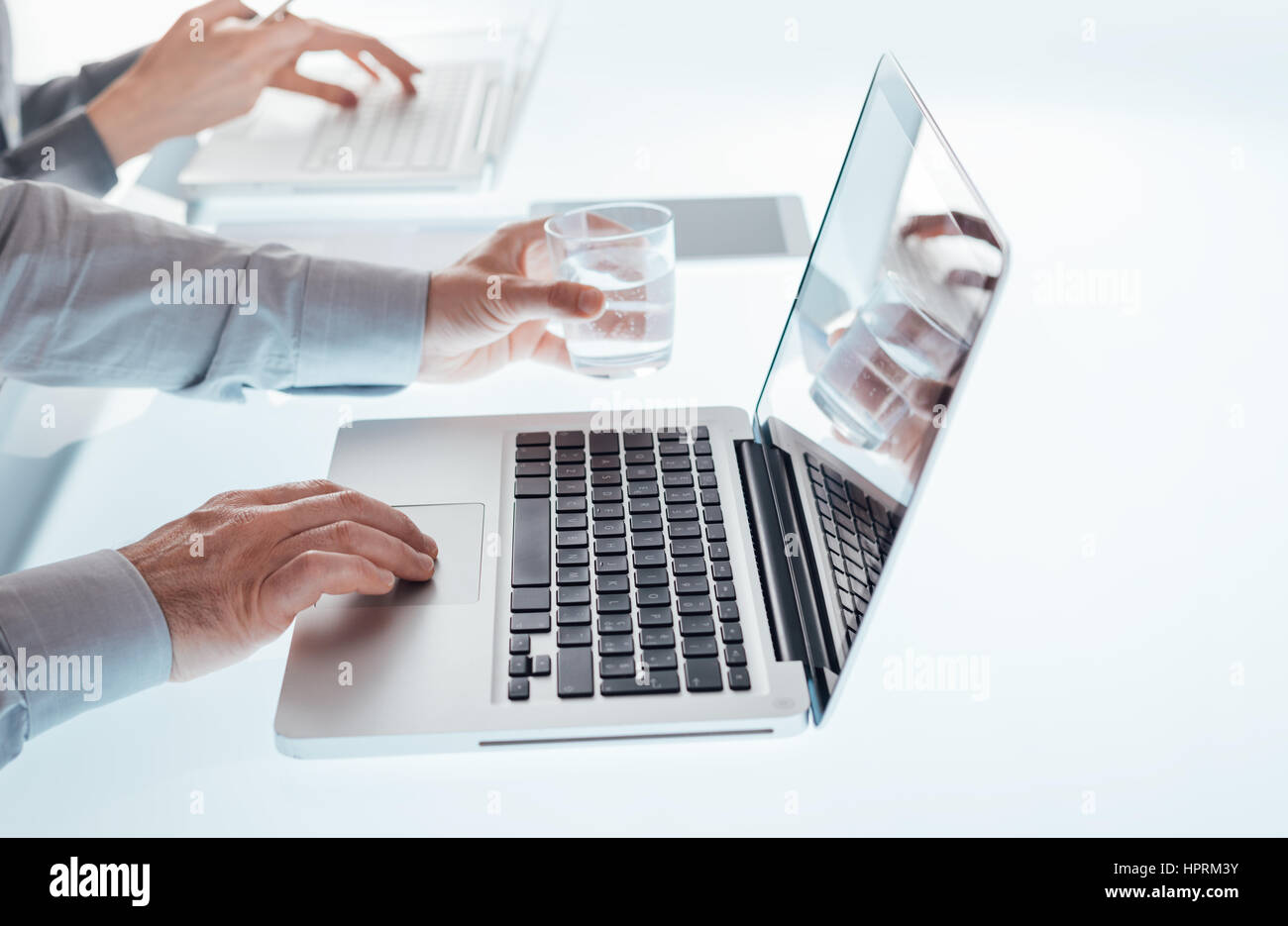 Business team working at office desk and typing on a laptop, hands ...