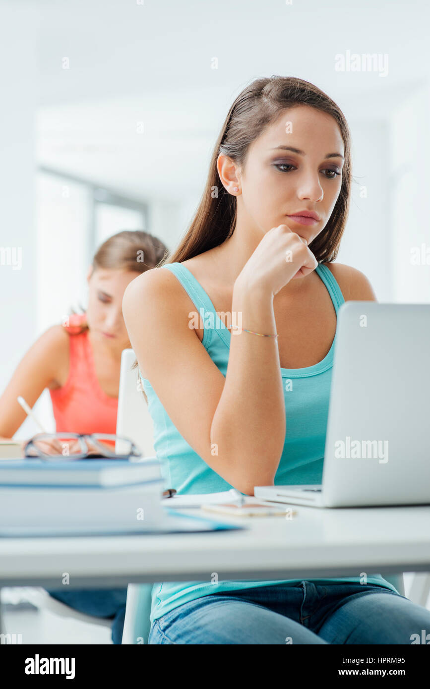 Young teen students in the classroom using laptops and sitting at ...