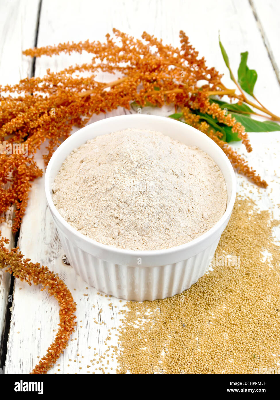 Amaranth flour in a bowl, seeds scattered on the table, brown flower ...