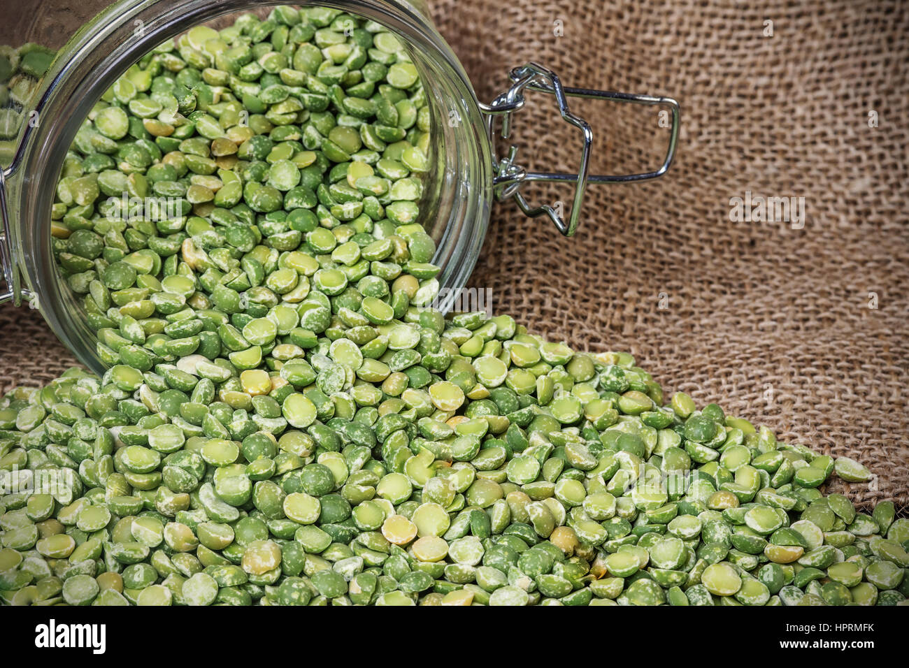 Spilled dried peas from the lying glass on burlap sack. Edited as a ...