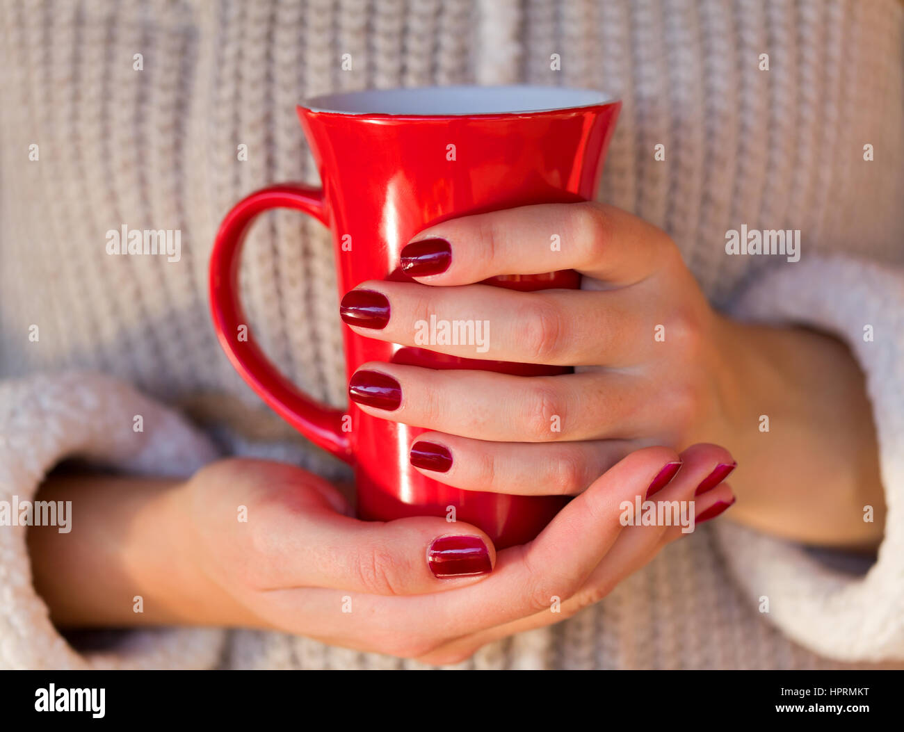 Picture of a woman's hand holding a red coffee mug Stock Photo - Alamy