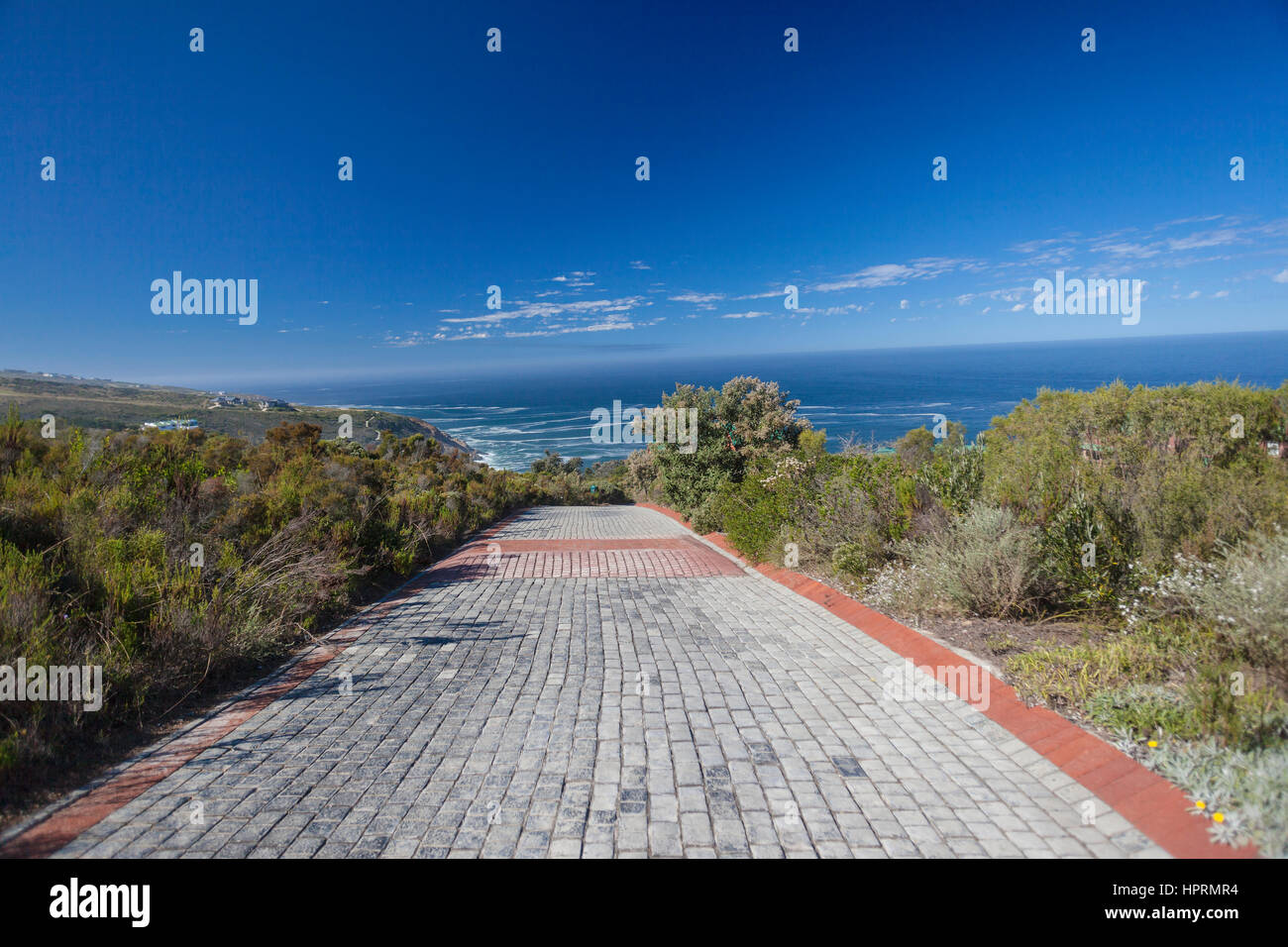 Cobble stone walkway driveway path towards blue ocean horizon landscape ...