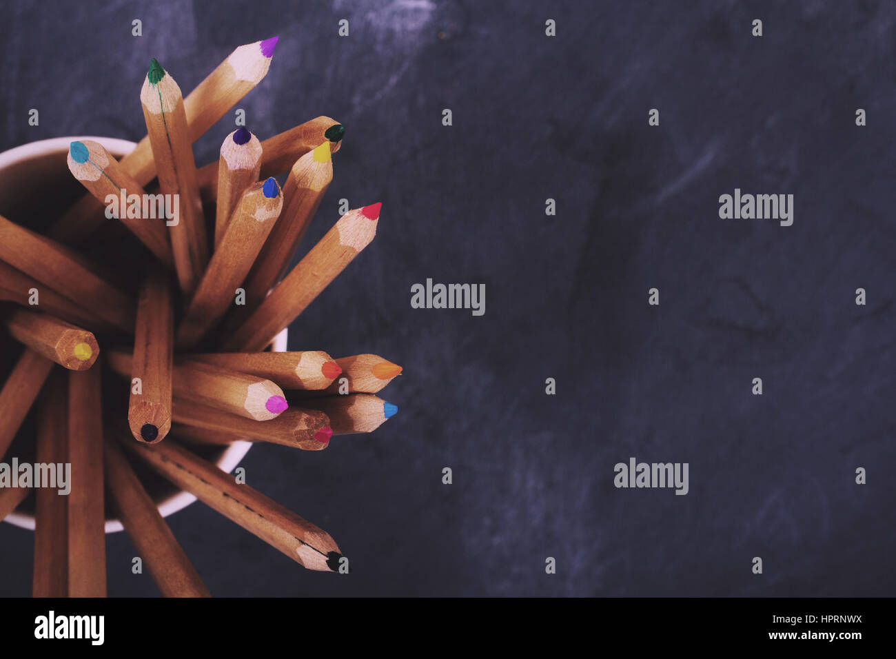 Close up of coloured pencils on a worn black background Vintage Retro ...