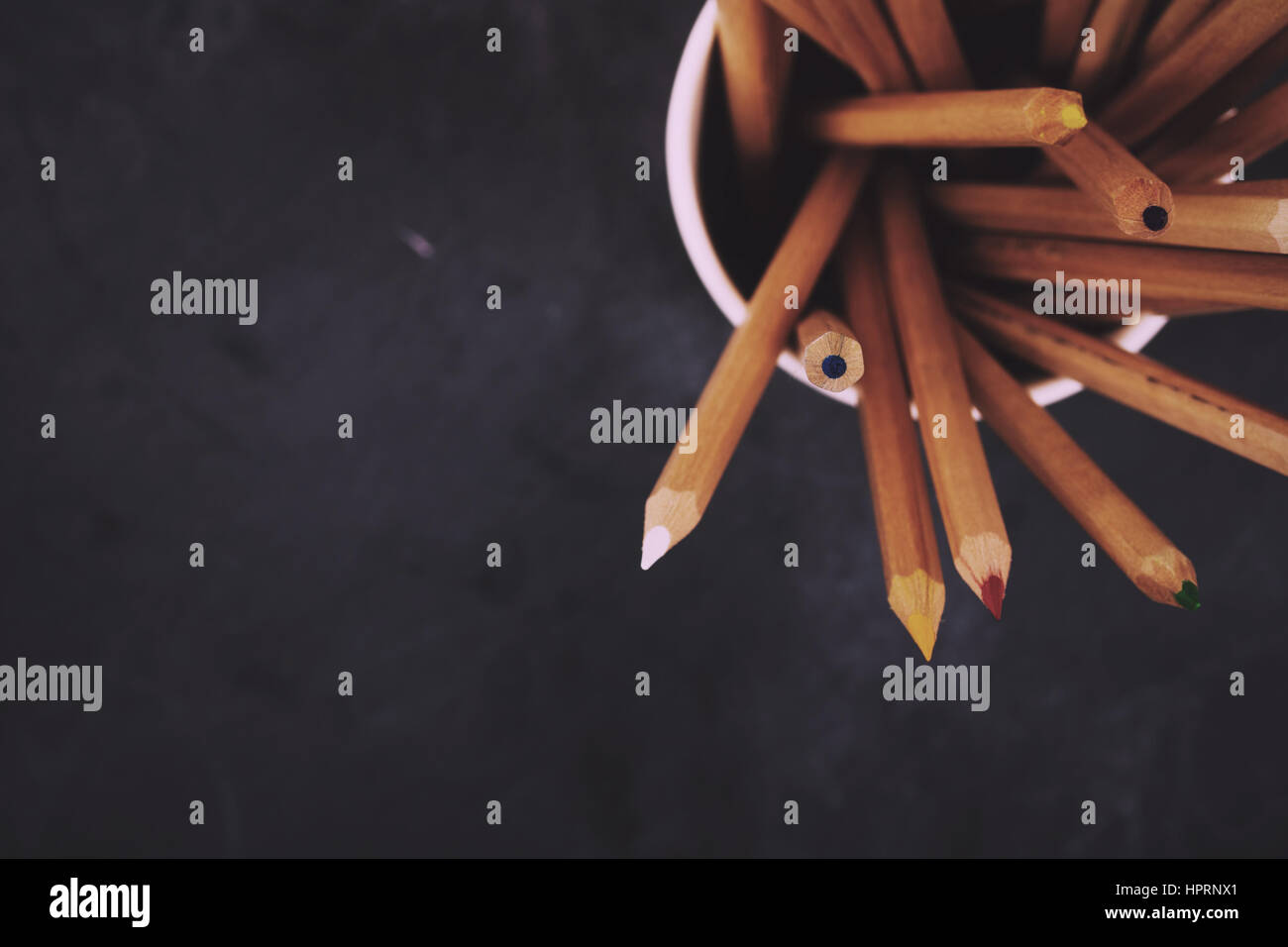 Close up of coloured pencils on a worn black background Vintage Retro ...