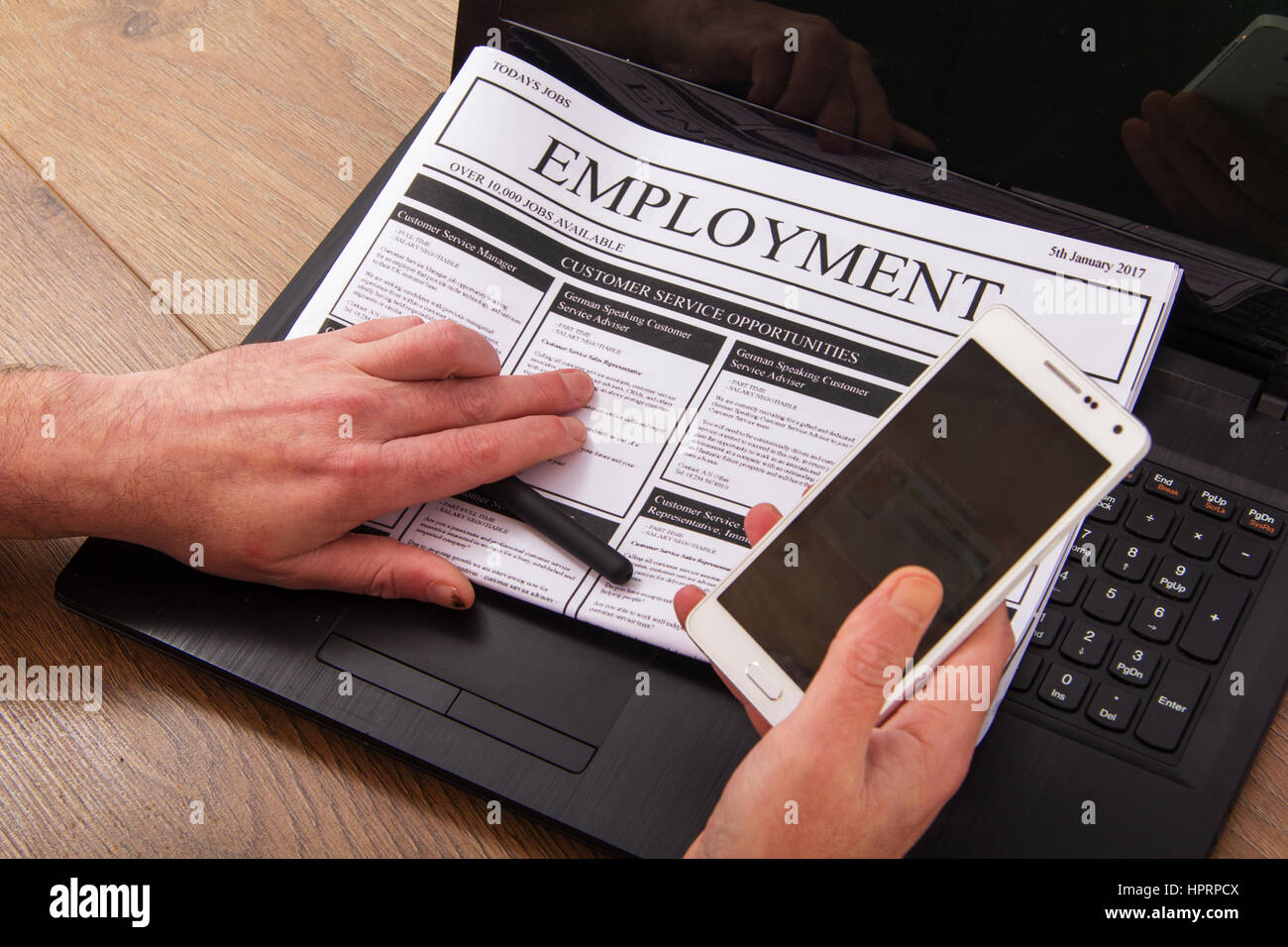 Searching for a new job or employment in a newspaper Stock Photo - Alamy