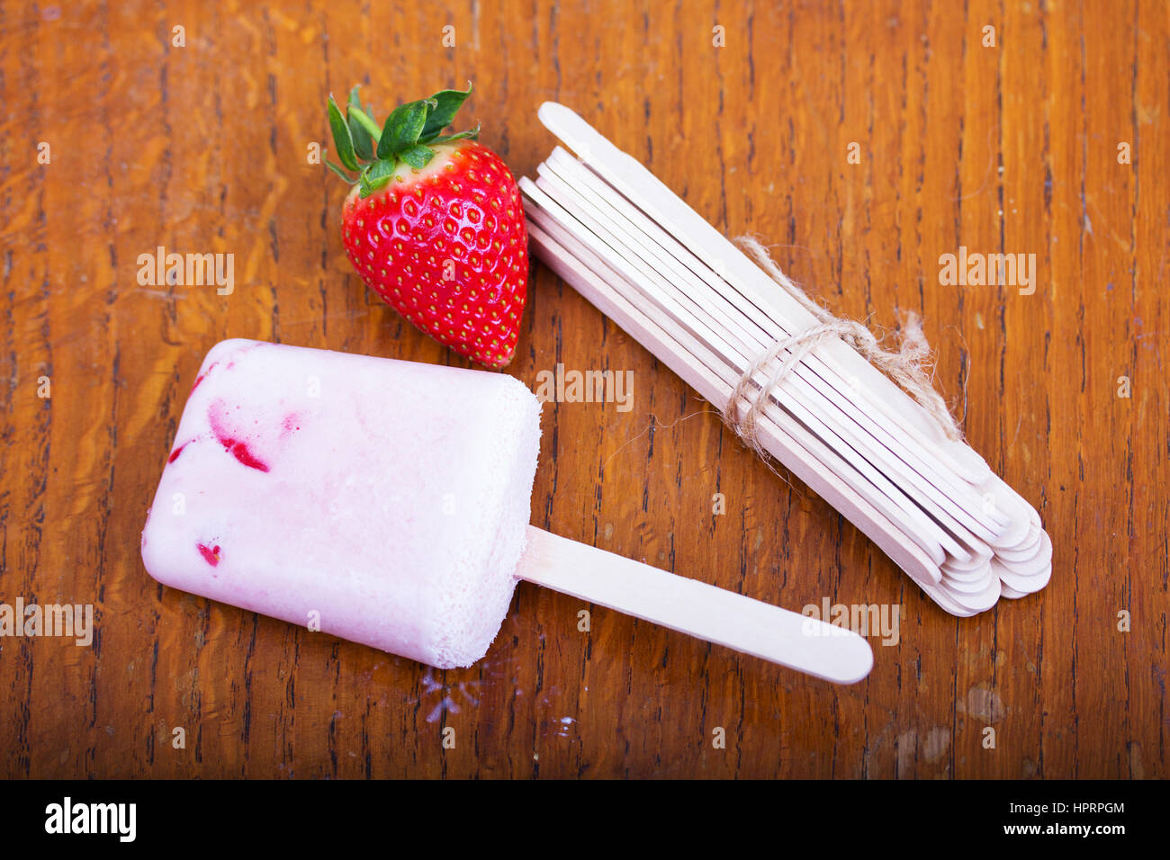 Homemade strawberry ice lolly on a rustic background Stock Photo - Alamy