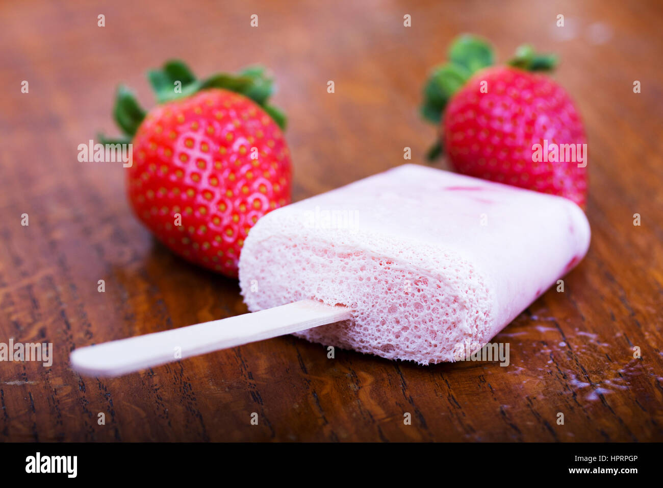 Homemade strawberry ice lolly on a rustic background Stock Photo - Alamy
