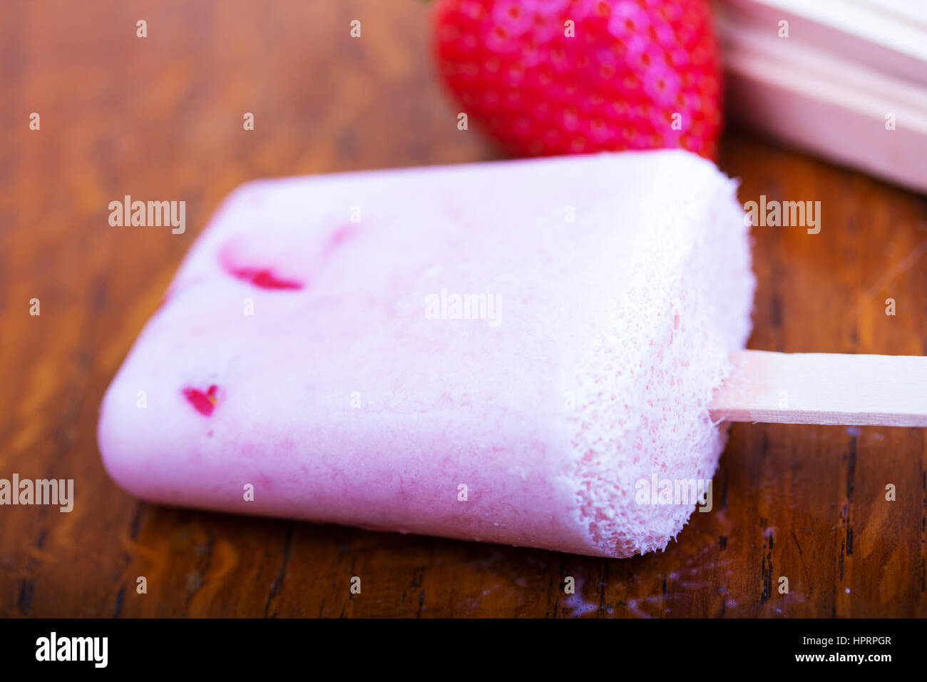 Homemade strawberry ice lolly on a rustic background Stock Photo - Alamy
