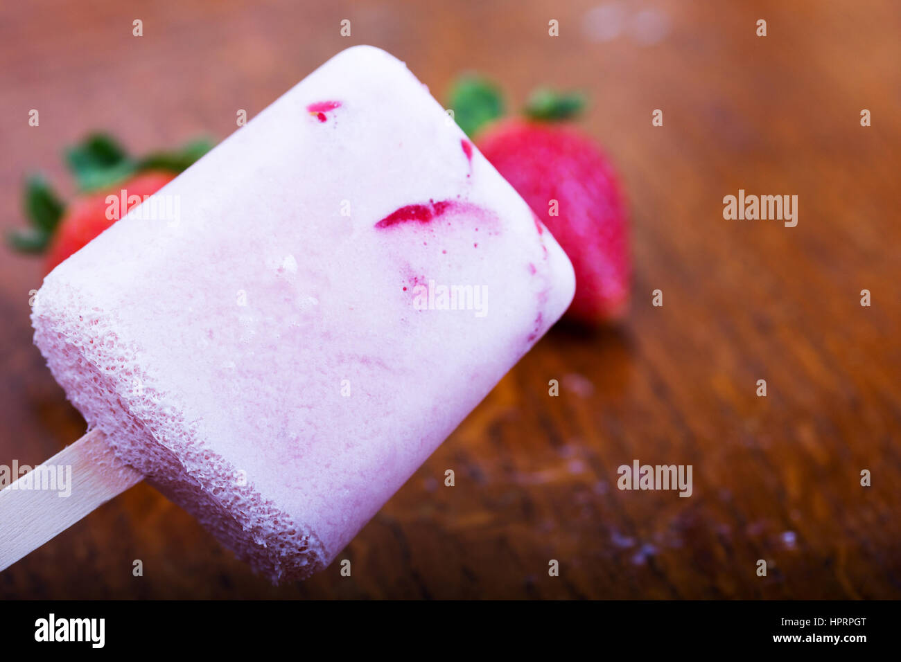Homemade strawberry ice lolly on a rustic background Stock Photo - Alamy