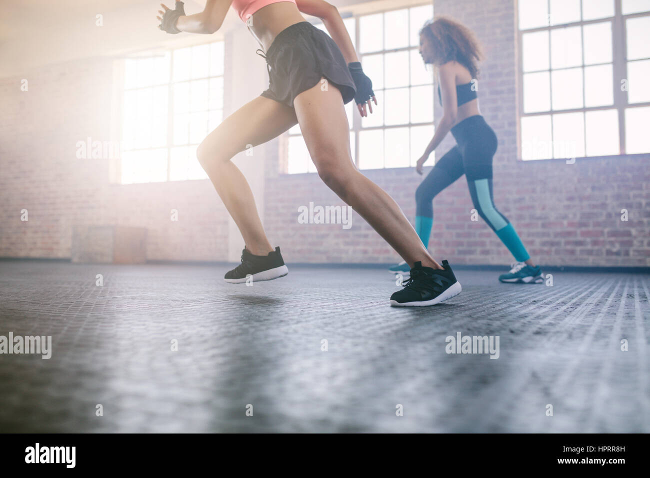 Low angle shot of females running in the gym. Legs of women exercising ...