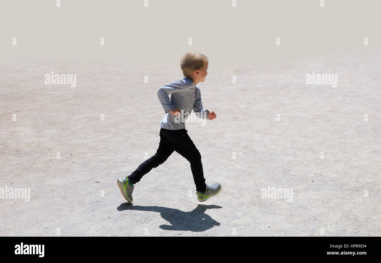 Little boy running isolated on the grey background Stock Photo - Alamy
