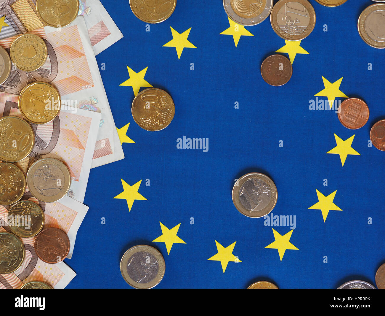 Euro banknotes and coins (EUR), currency of European Union over flag of ...