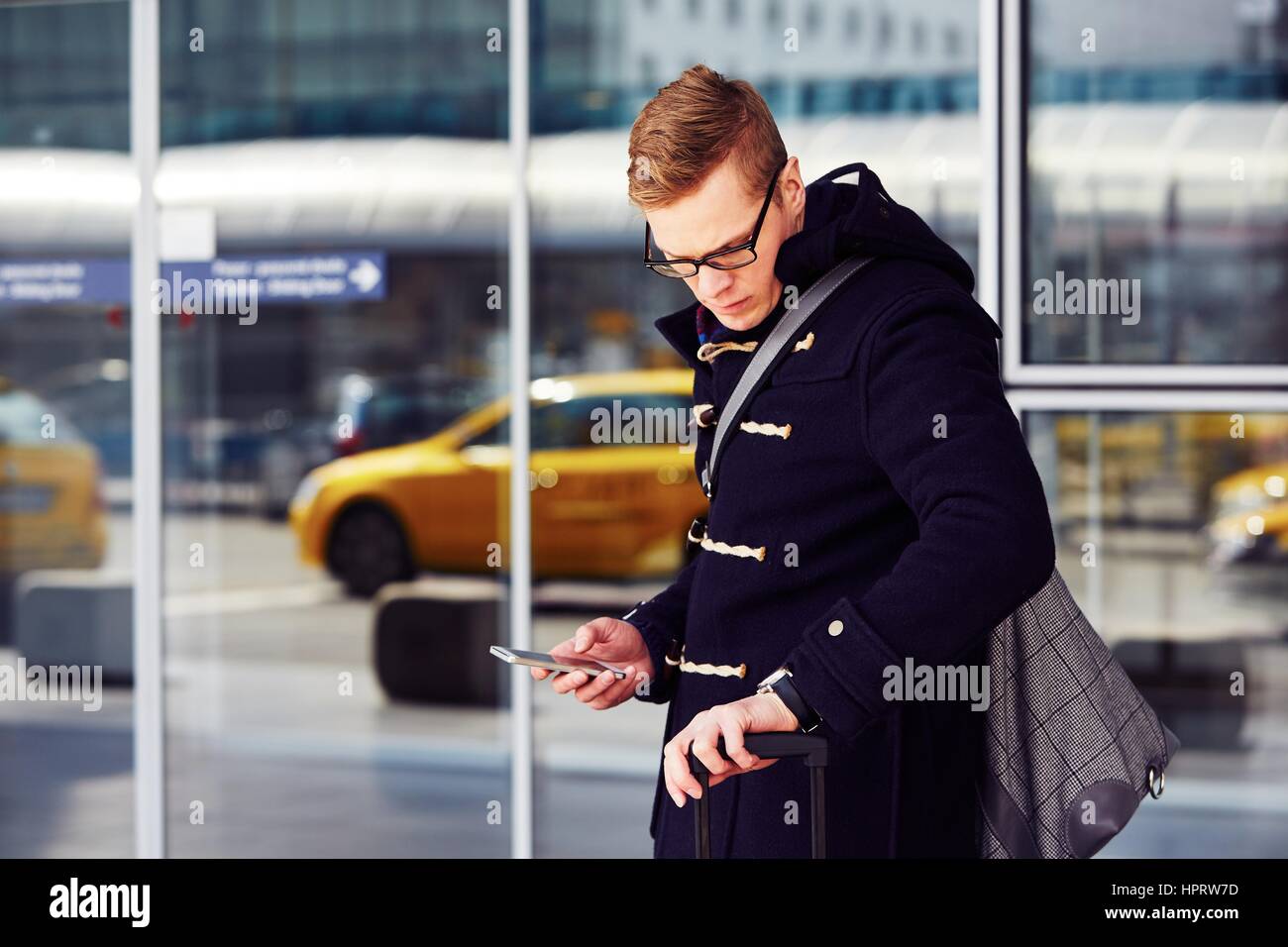 Young man is waiting for taxi at the airport Stock Photo - Alamy