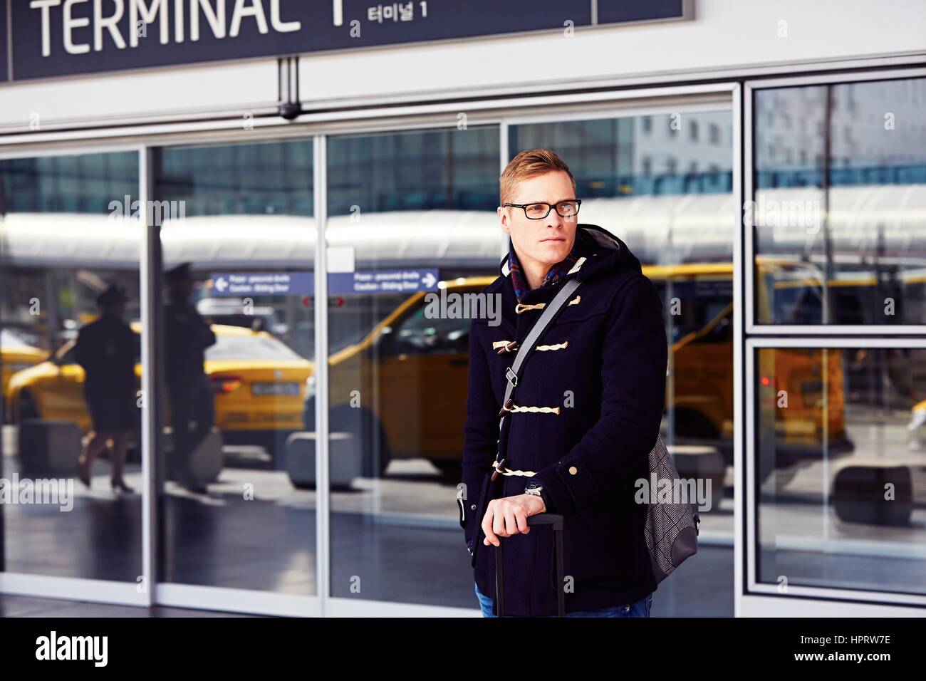 Young man is waiting for taxi at the airport Stock Photo - Alamy