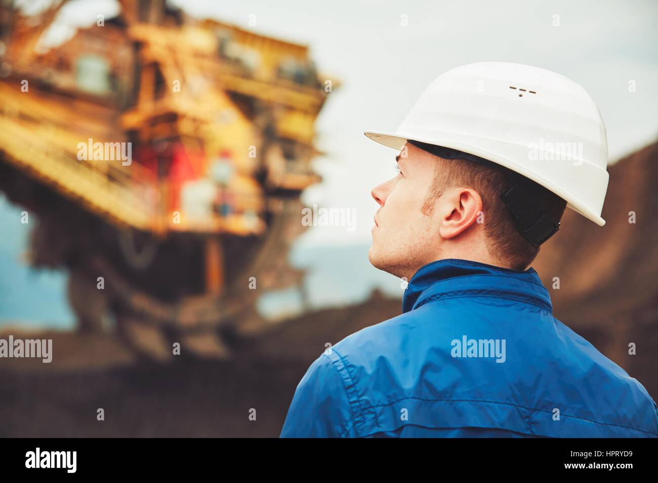 Coal mining in an open pit - Worker is looking on the huge excavator ...