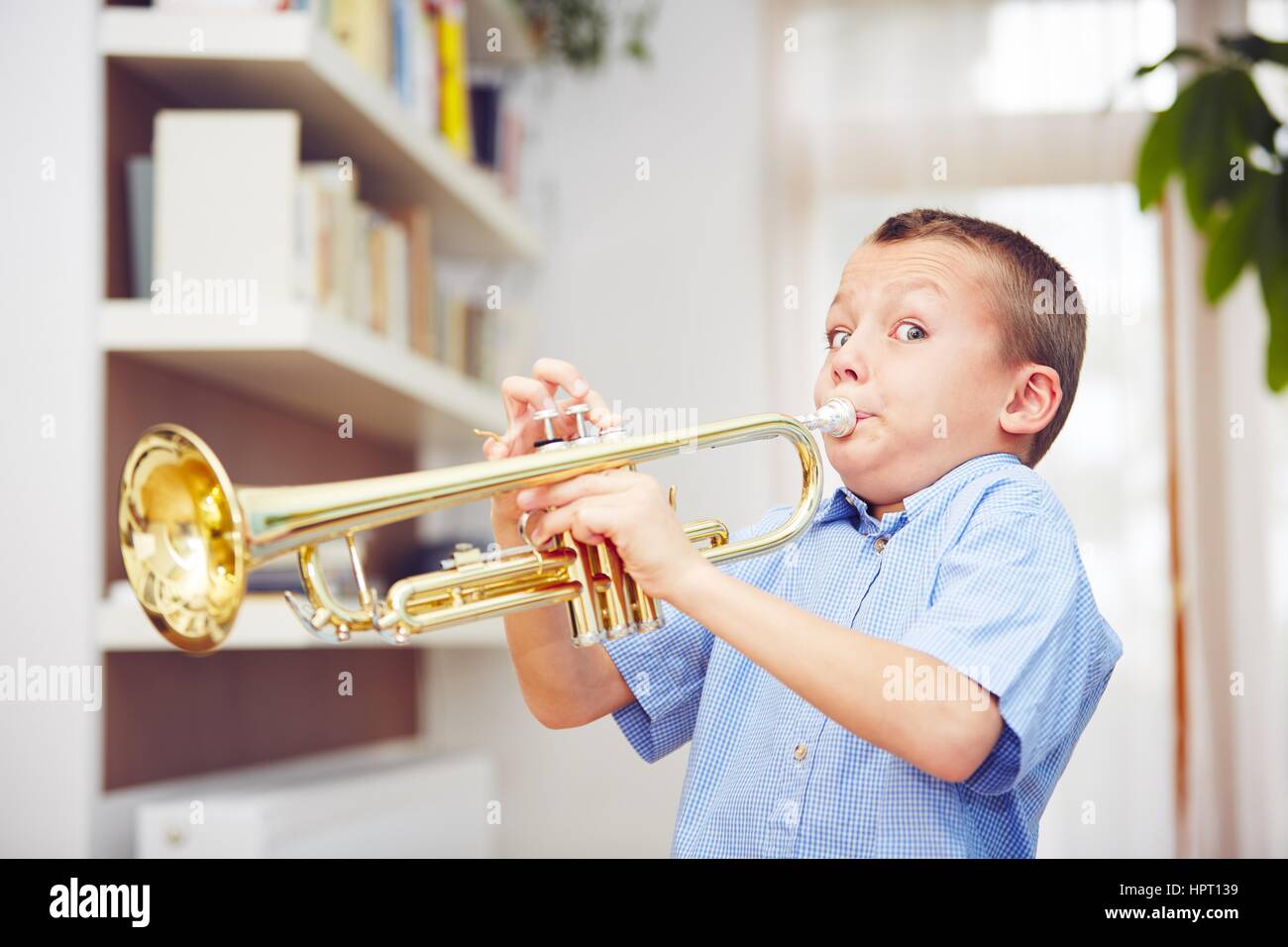 Little boy is playing the trumpet at home Stock Photo - Alamy
