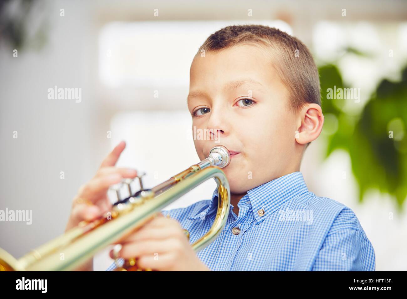 Little boy is playing the trumpet at home Stock Photo - Alamy