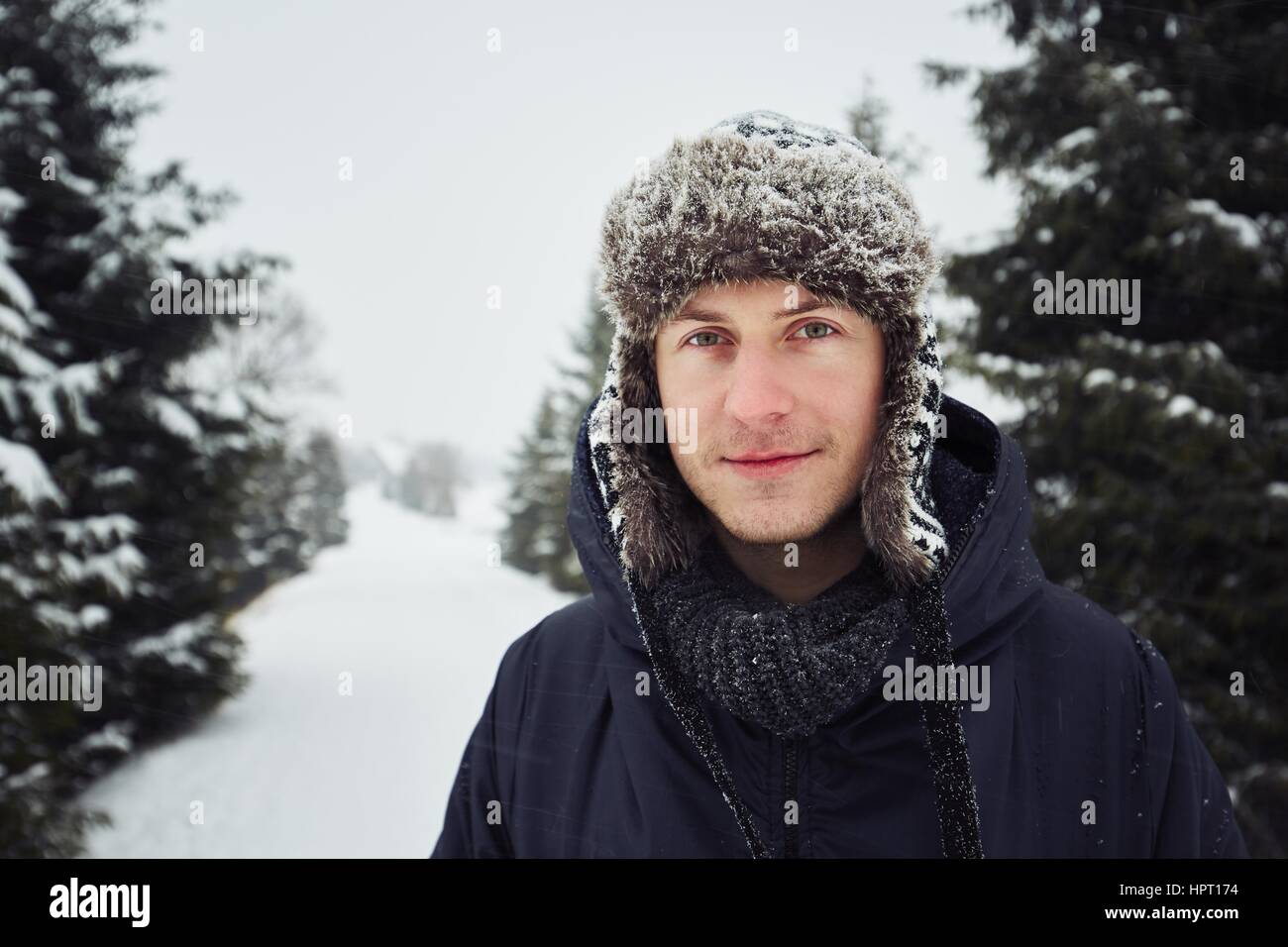 Portrait of young man outdoors in winter under snowstorm Stock Photo ...