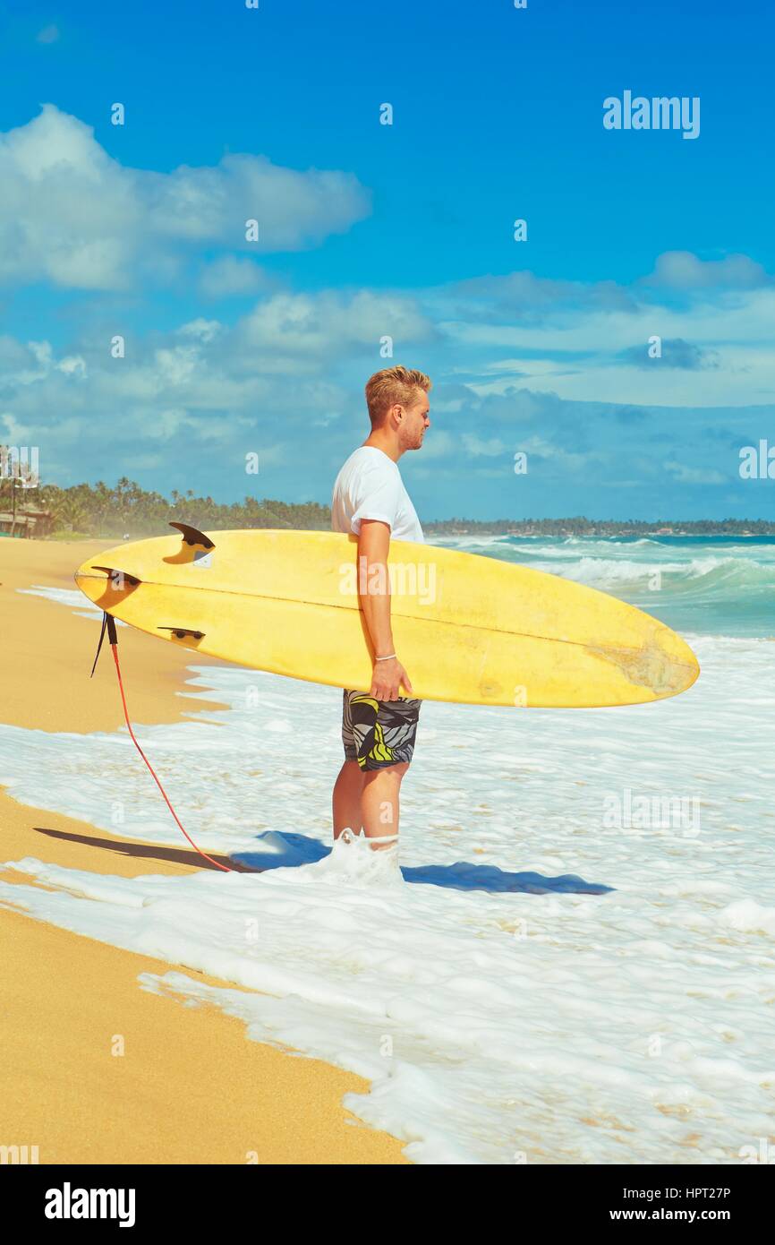 Man with surfboard on the beach at sunset Stock Photo - Alamy