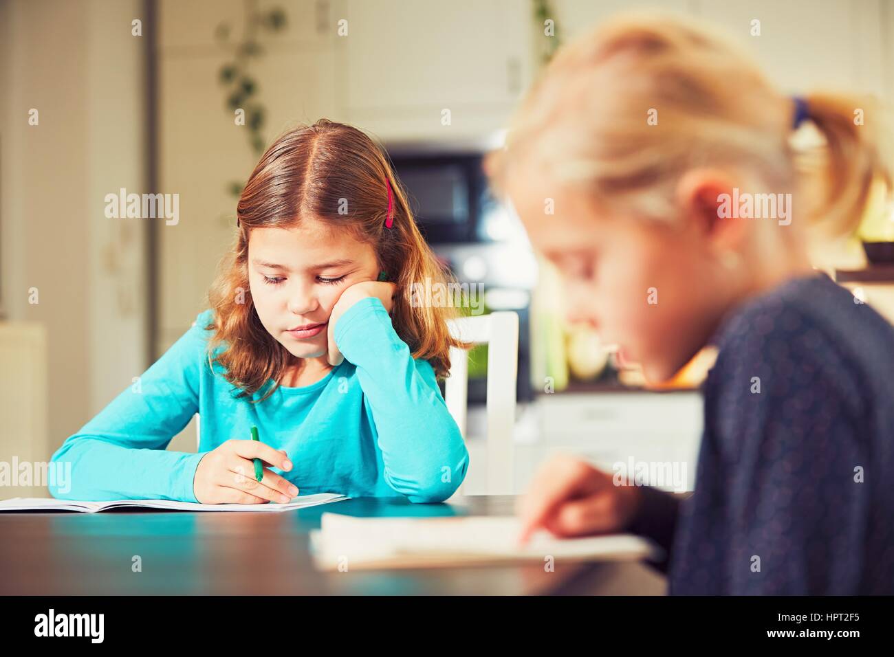 Little siblings with school books are doing his homework for elementary ...