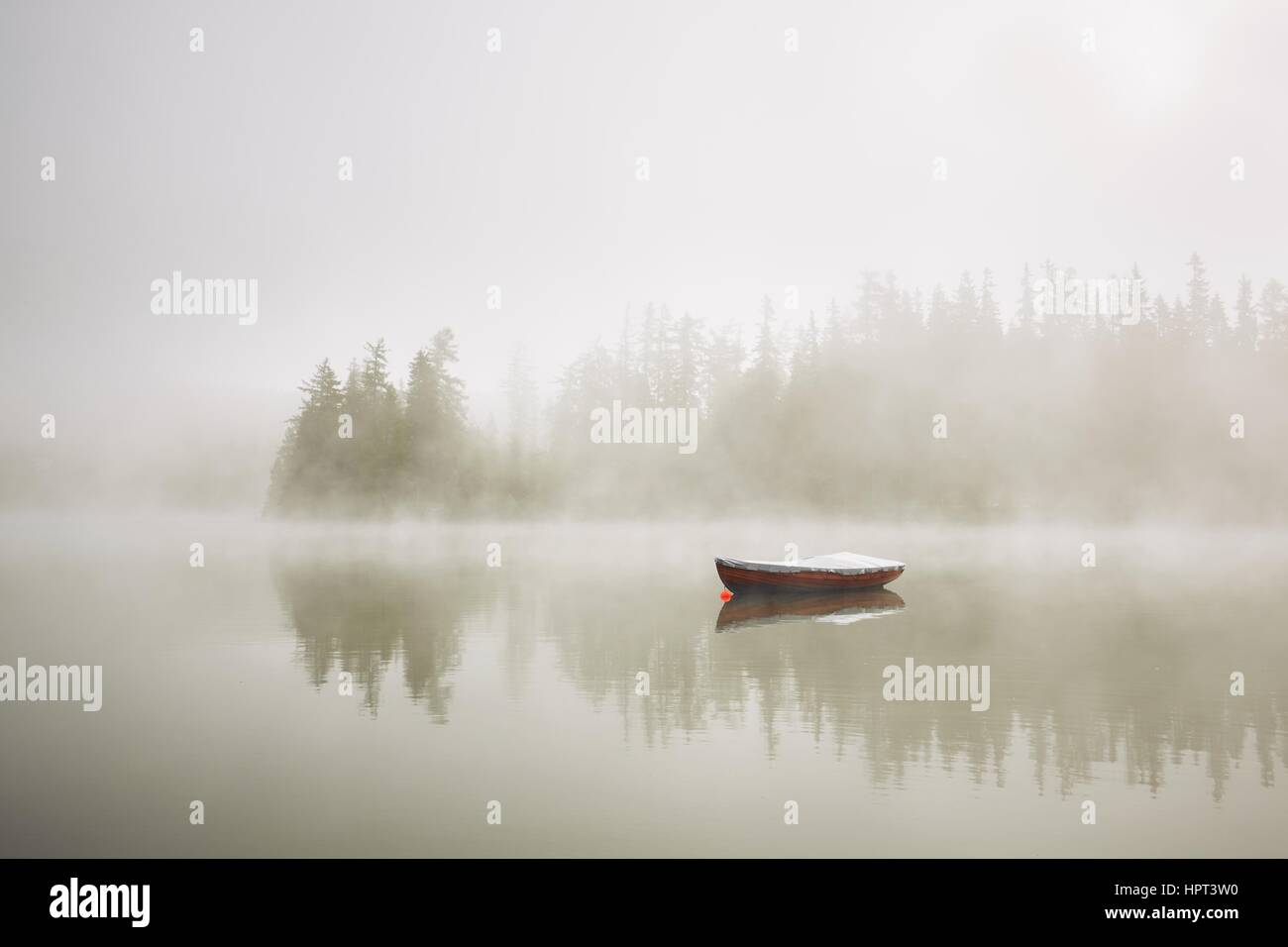 Boat on the lake at morning fog Stock Photo - Alamy