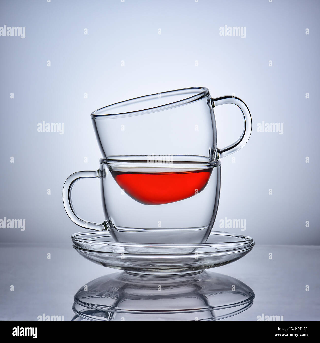 Two cups of clear glass of tea, facing each other with saucers Stock ...