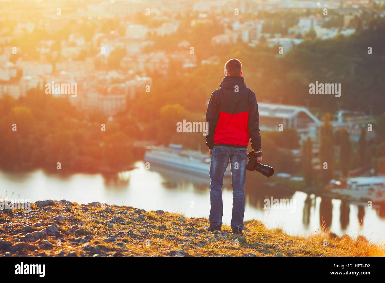 Young photographer is enjoying sun. Photographer with mirror camera is ...