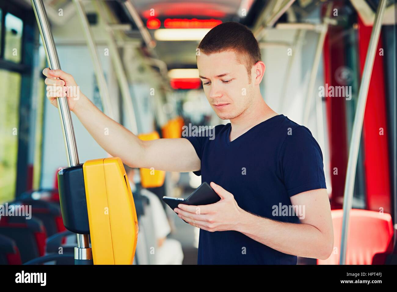 Everyday life and commuting to work by bus (tram). Handsome man is ...