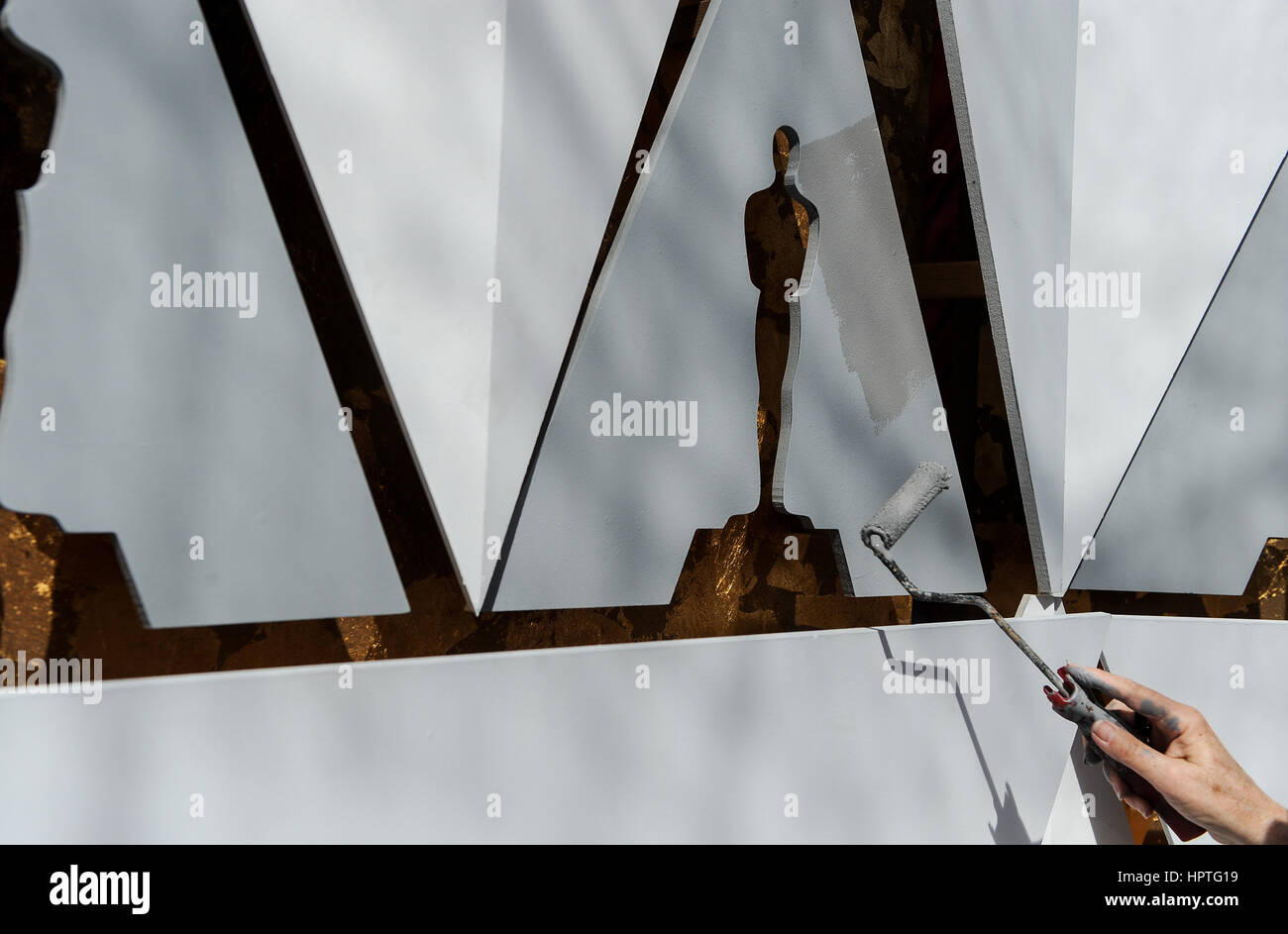 Los Angeles, USA. 24th Feb, 2017. A worker paints an Oscar background ...