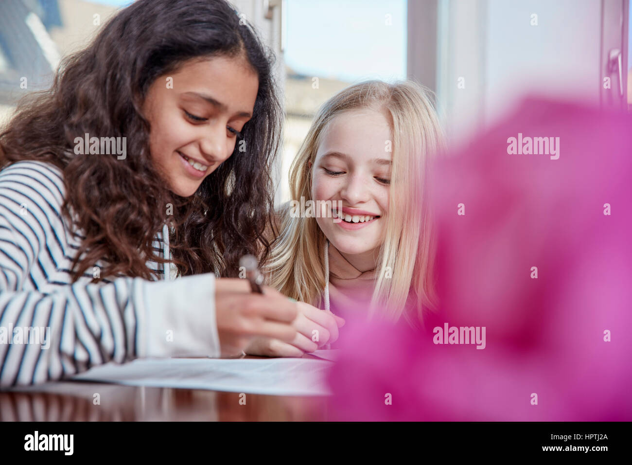 Two girls doing homework together Stock Photo - Alamy